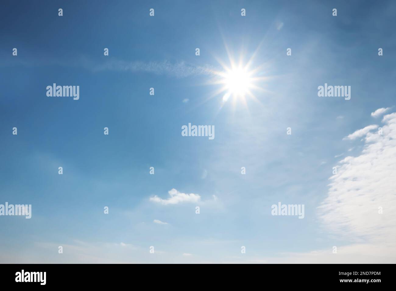 Sun and white clouds in blue sky outdoors Stock Photo - Alamy