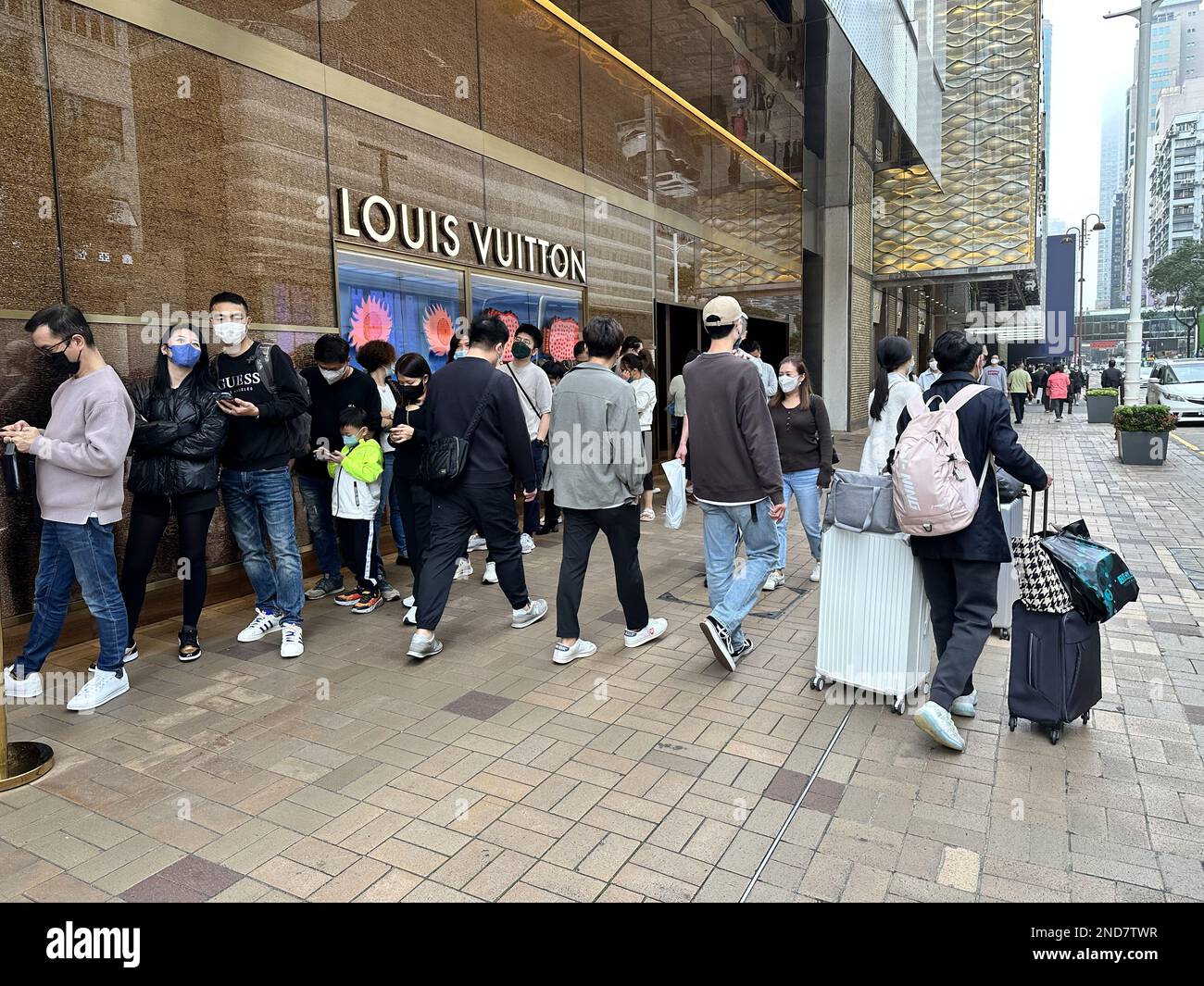 Shoppers queue outside a luxury retail store in Tsim Sha Tsui. 12FEB23 ...