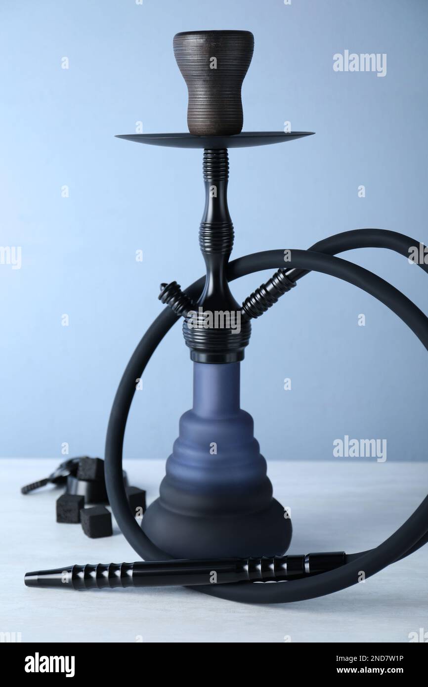 Traditional hookah on white table against light blue background Stock ...