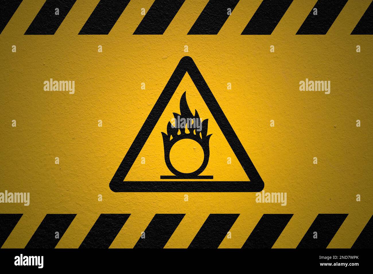 Black striped yellow background with a Self ignition warning sign and a ...