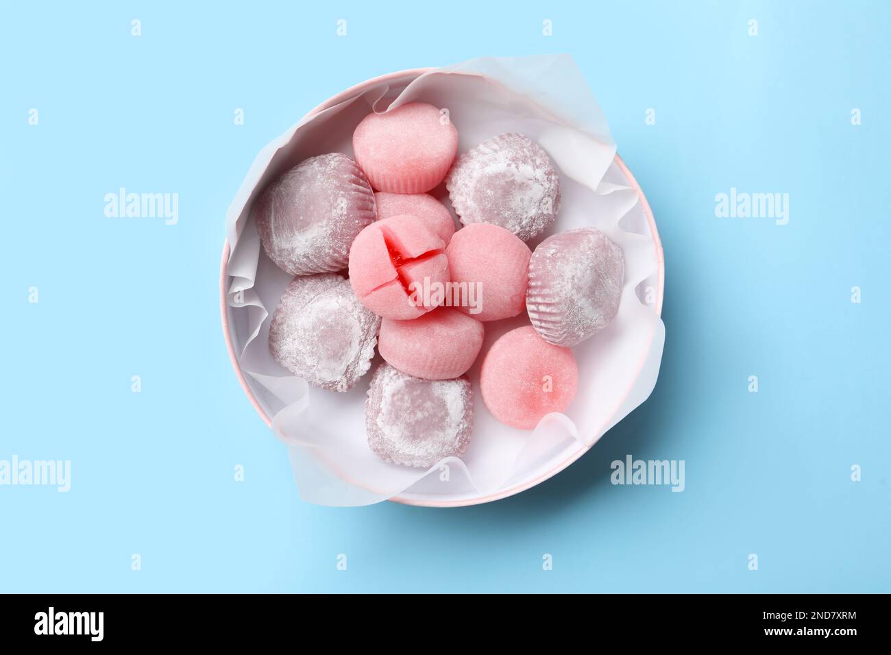 Many different delicious mochi in box on light blue background, top ...