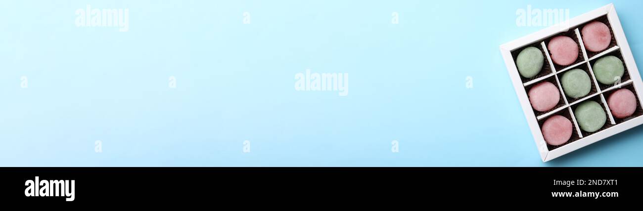 Many different delicious mochi in box on light blue background, top ...