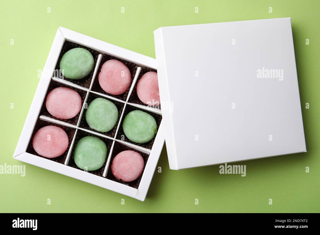 Many different delicious mochi in box on green background, top view ...