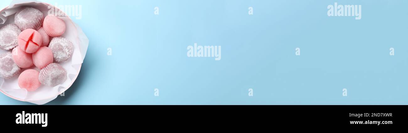 Many different delicious mochi in box on light blue background, top ...