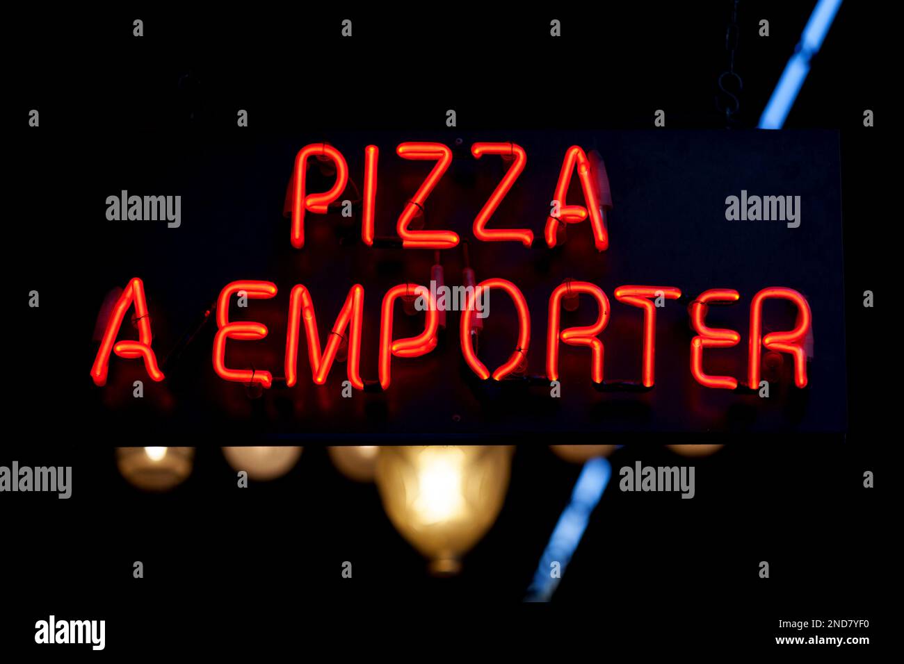 Red neon light shaped into the french phrase "Pizza à emporter ...