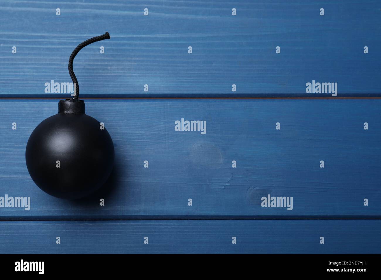 Old fashioned fuse bomb on blue wooden table, top view. Space for text ...
