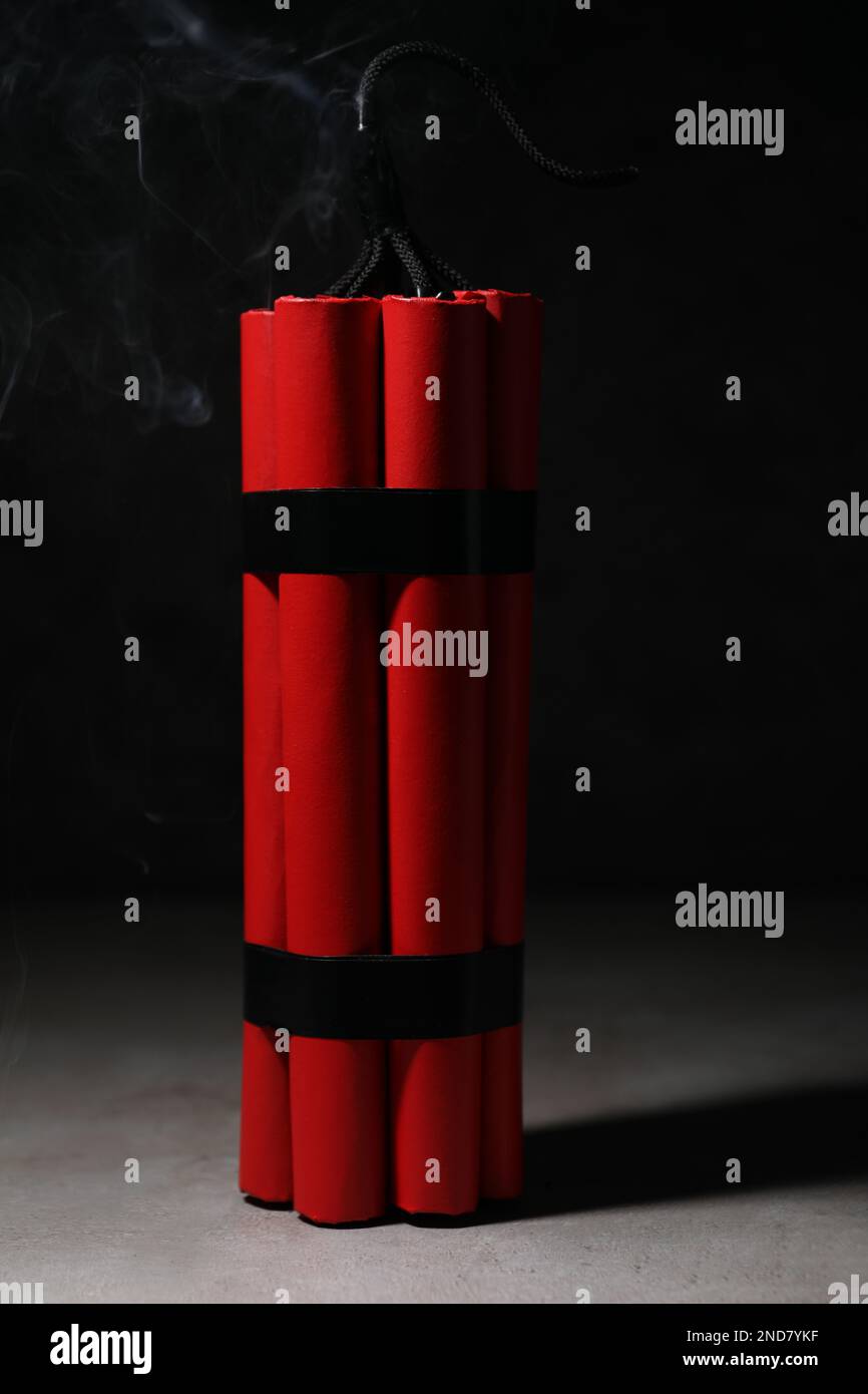 Dynamite bomb on grey table against black background Stock Photo - Alamy