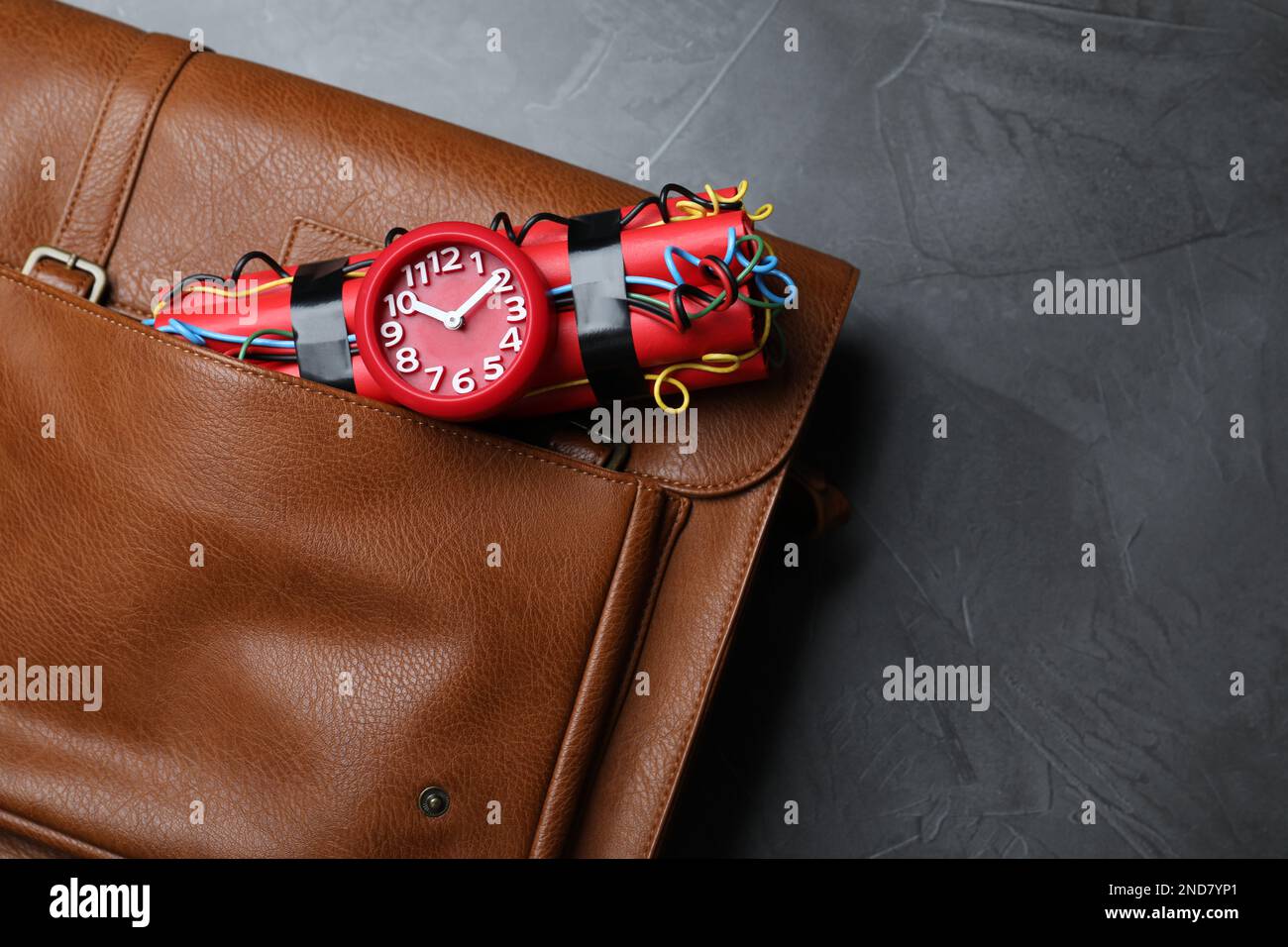 Leather briefcase with dynamite time bomb on grey table, top view ...