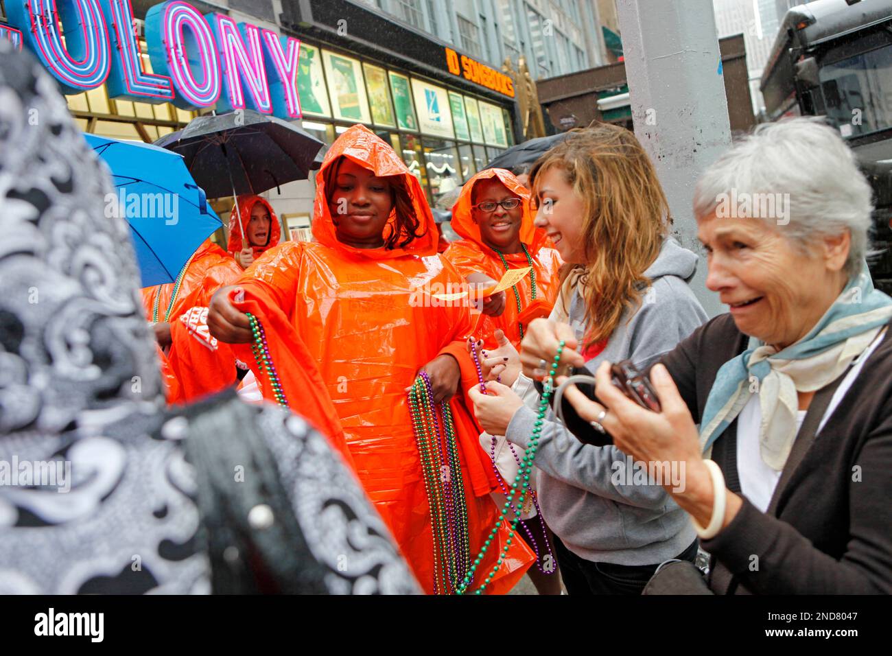 Members of a flash mob pass out beads to pedestrians in celebration of ...