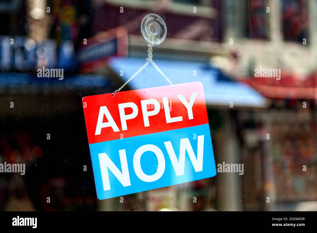 Red and blue sign in the window of a shop saying "Apply now Stock Photo ...