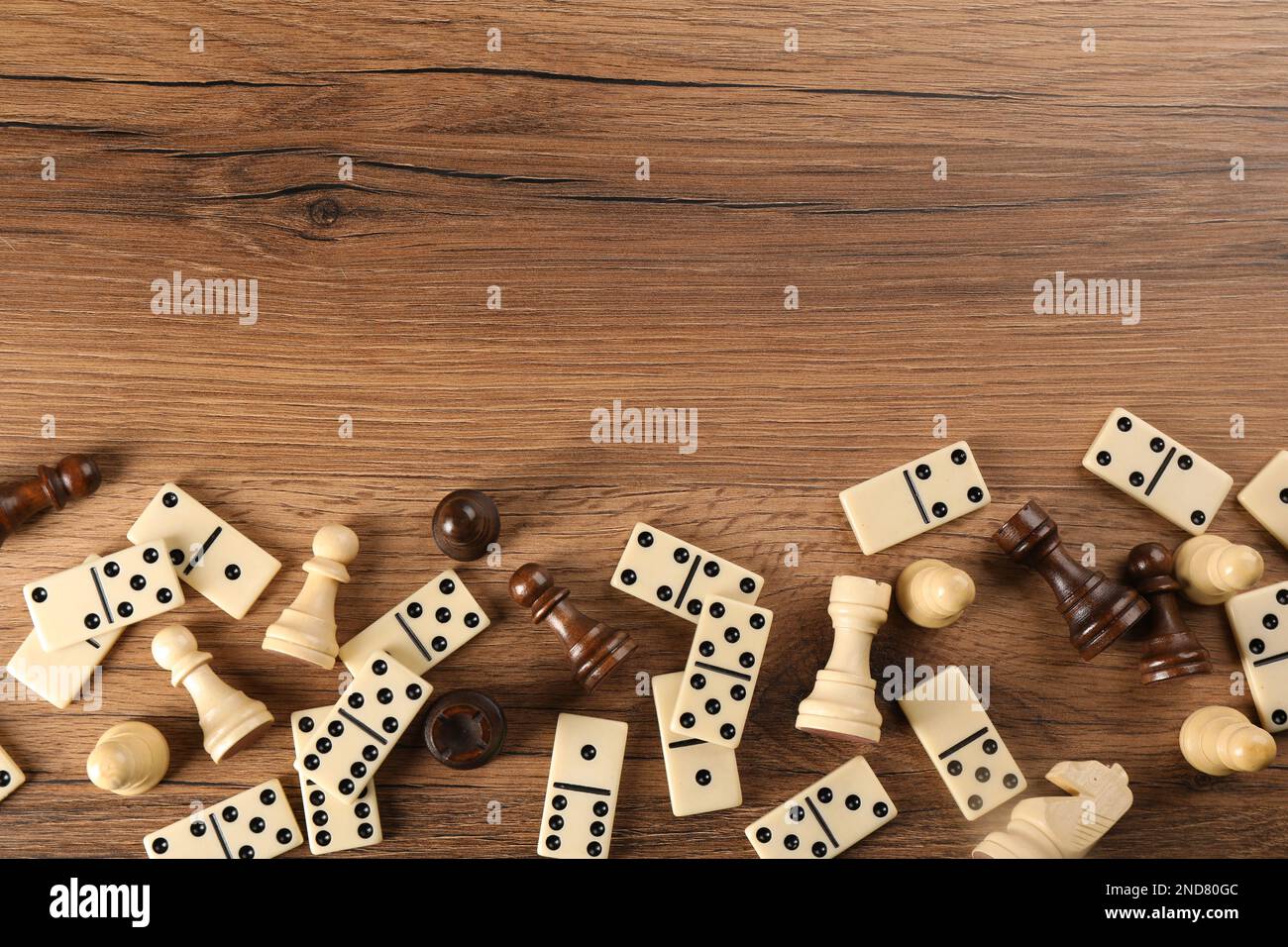 Flat lay composition of chess pieces and dominoes on wooden table ...