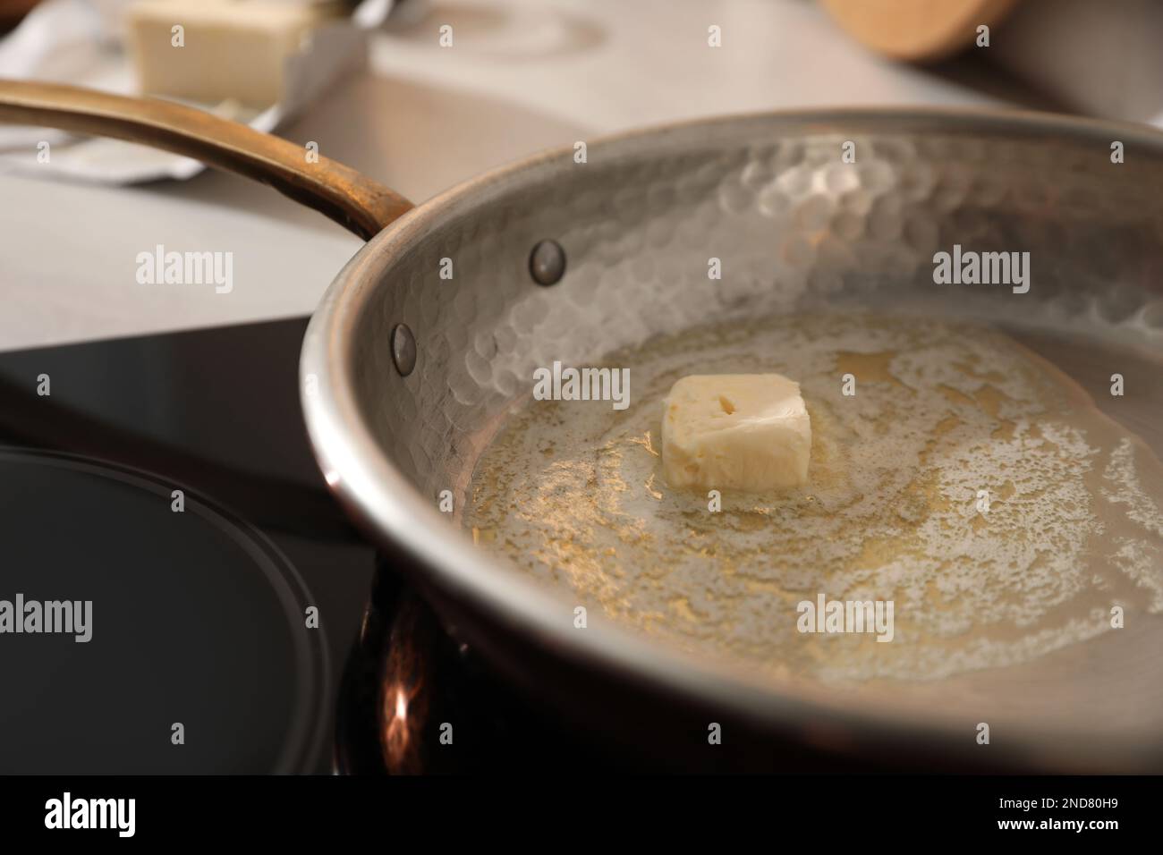Frying pan with melted butter on stove, closeup Stock Photo - Alamy