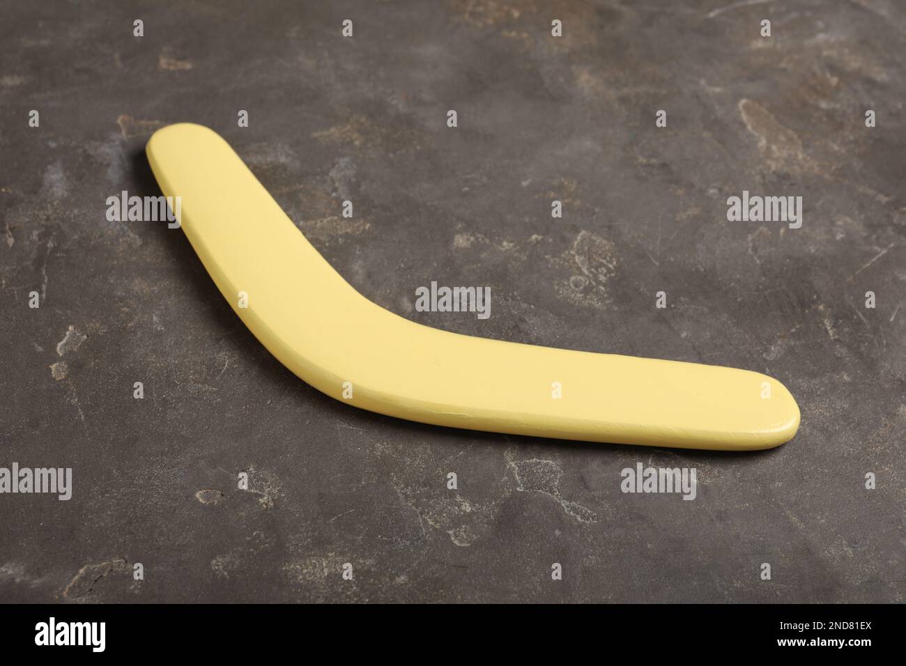 Yellow boomerang on grey stone background. Outdoors activity Stock ...