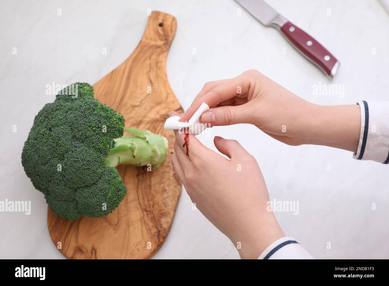 Woman cut finger while cooking at table, above view Stock Photo - Alamy