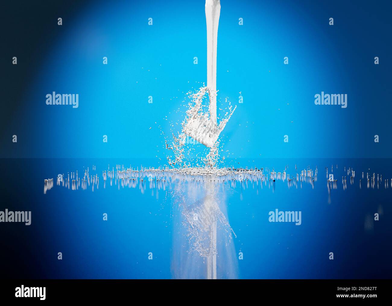 A white liquid stream falling into a puddle of water in the middle of a ...