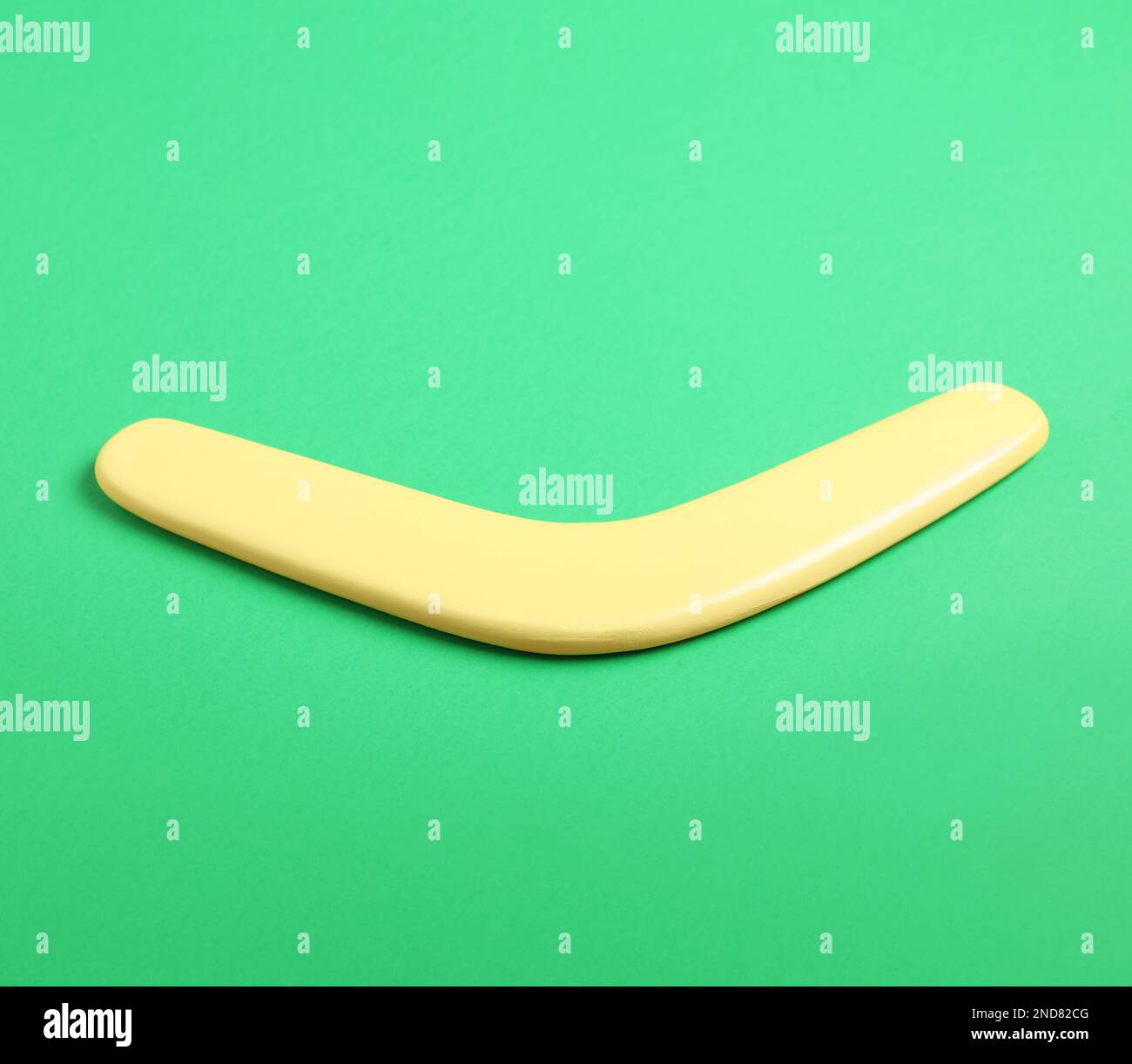 Yellow wooden boomerang on green background. Outdoor activity Stock ...