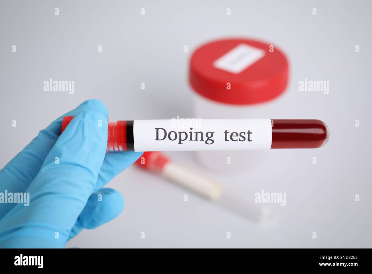 Doctor holding test tube with blood sample over table, closeup. Doping ...