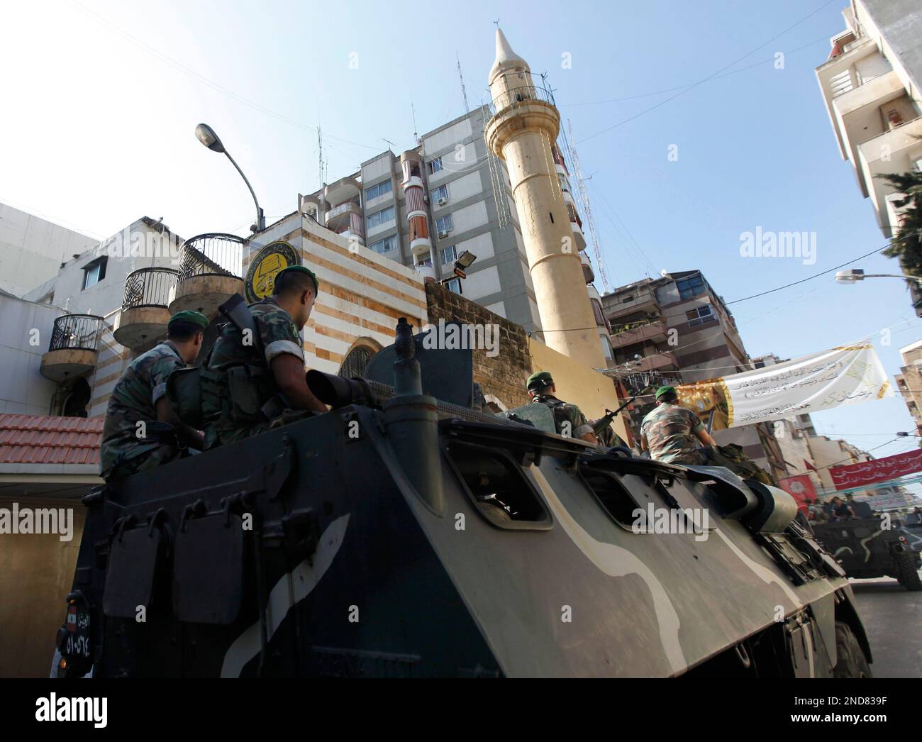 Lebanese soldiers patrol the area on an armored vehicle, near a mosque ...
