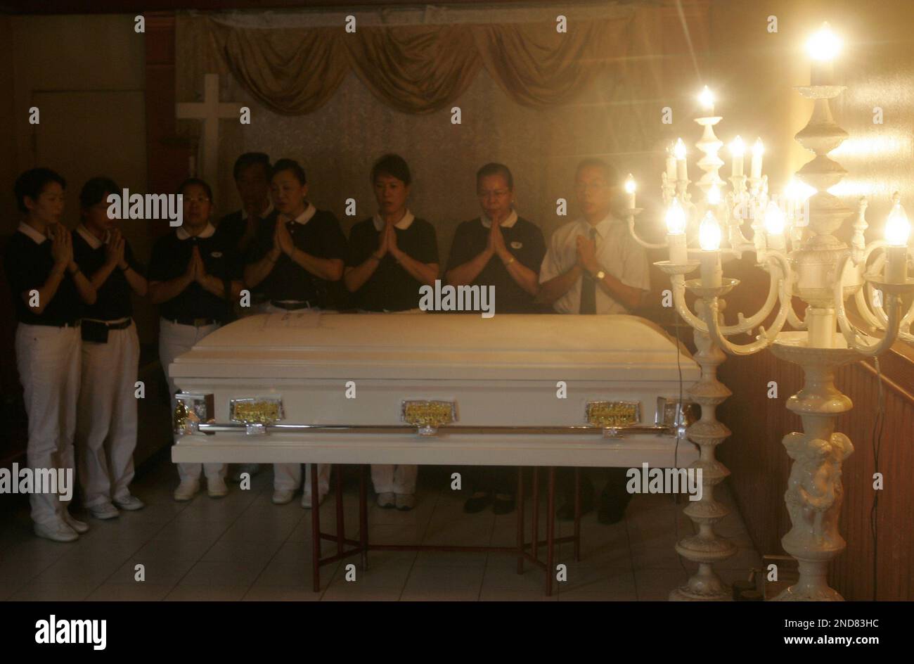 Filipino-Chinese pray beside a coffin bearing one of the Hong Kong ...