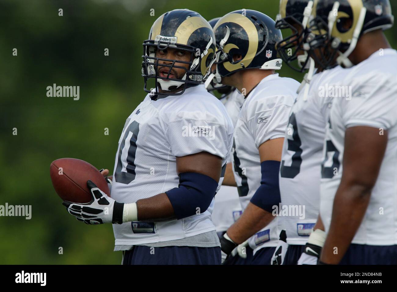 St. Louis Rams center Jason Brown, left, holds a football during NFL ...