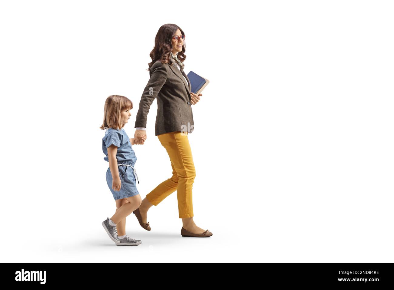 Full length profile shot of a woman walking carrying books and holding ...