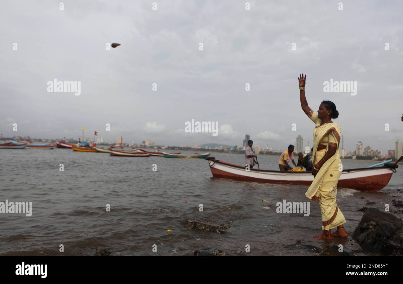 An Indian fisher woman throws a coconut into the sea to celebrate the ...