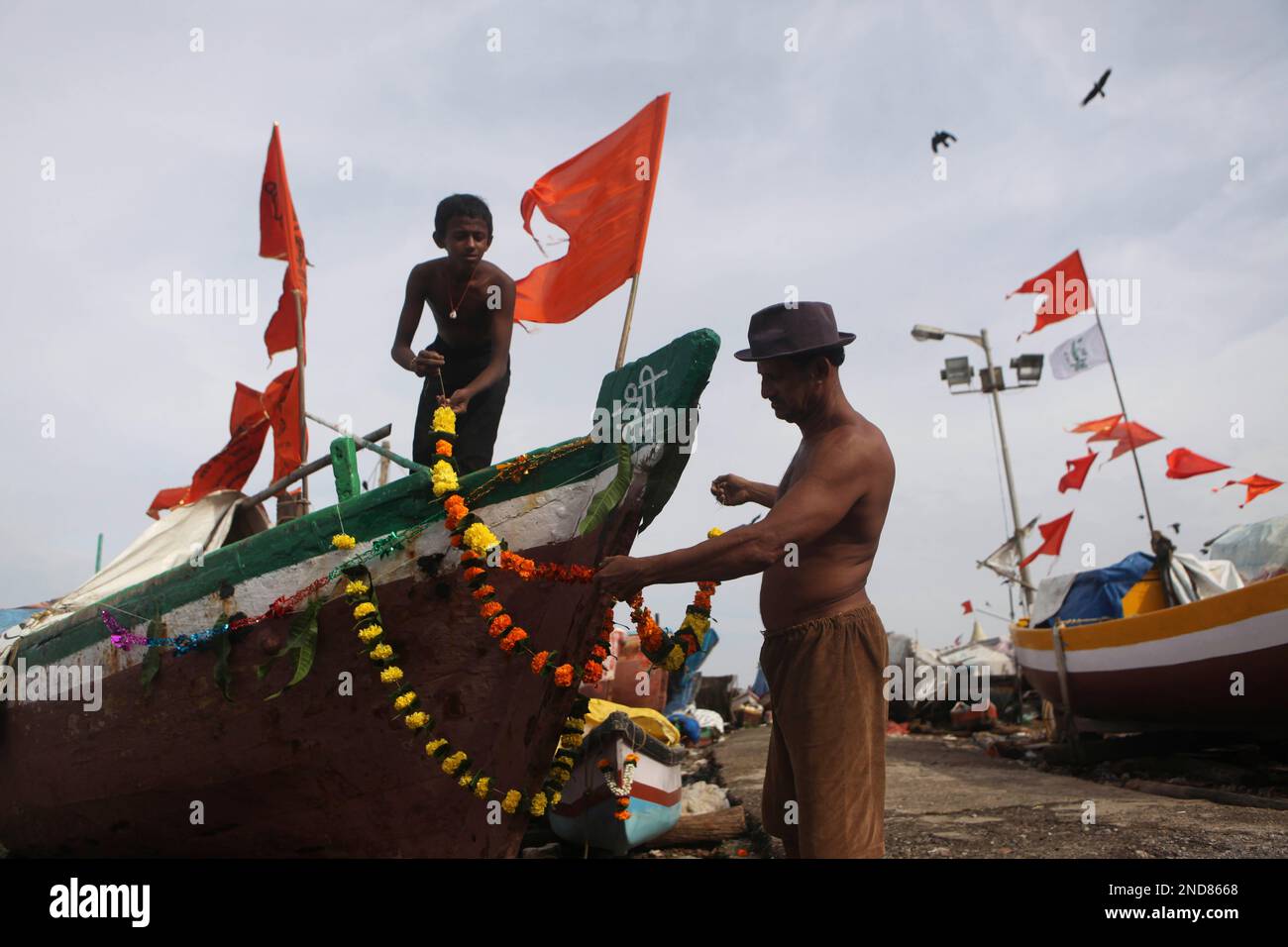 An Indian fisherman decorates his boat for the 'Nariyal Poornima ...
