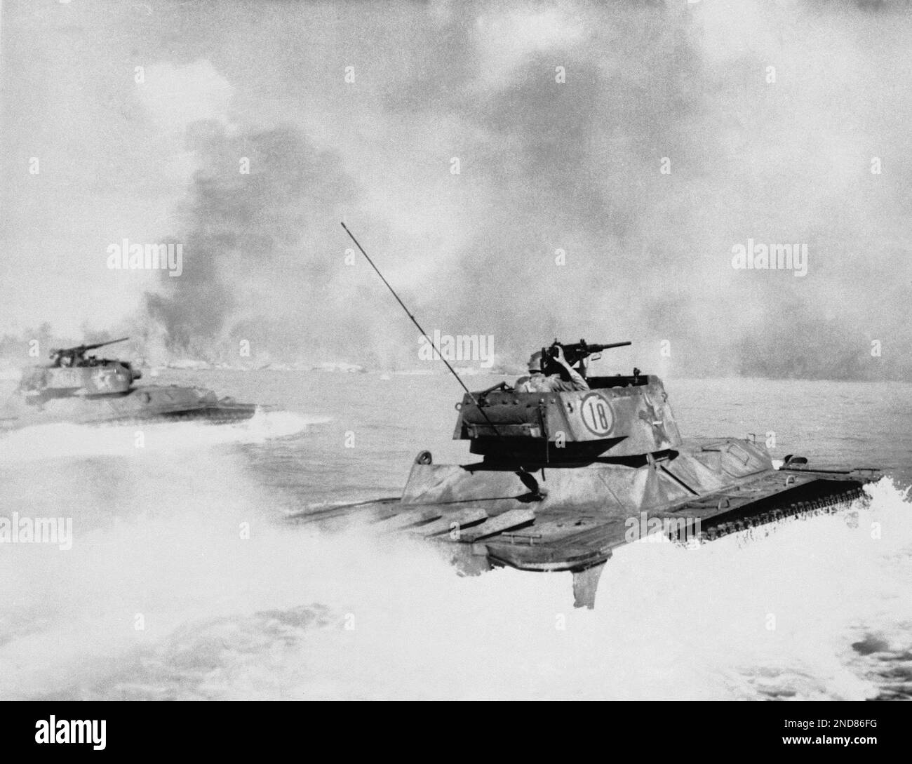 Machine guns and cannon ready, two of a wave of Marine amphibious tanks ...