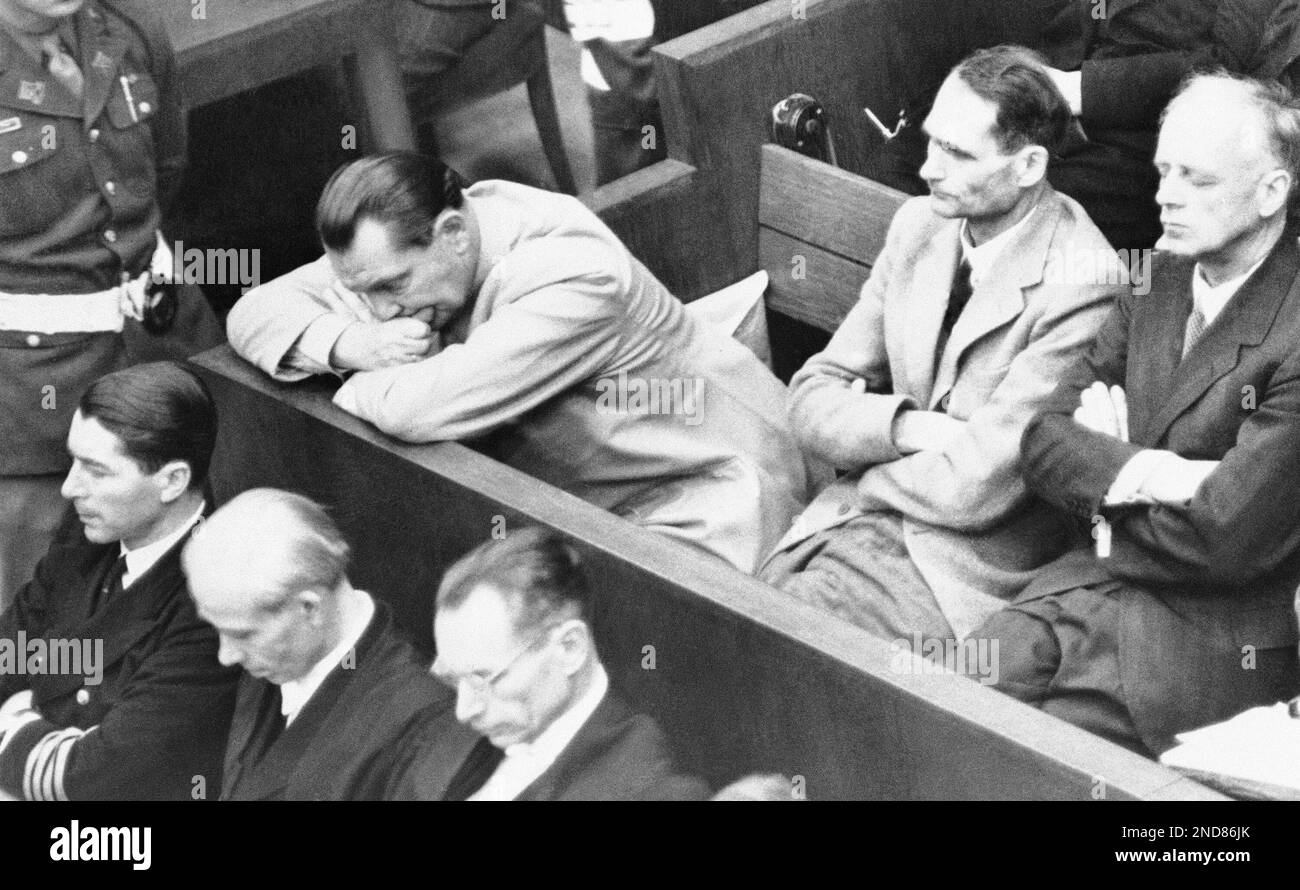 Hermann Goering leaned forward in the dock and meditatively bit his ...