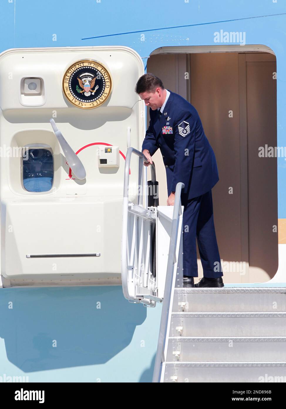 A U.S. Air Force Master Sergeant opens the door on Air Force One and ...