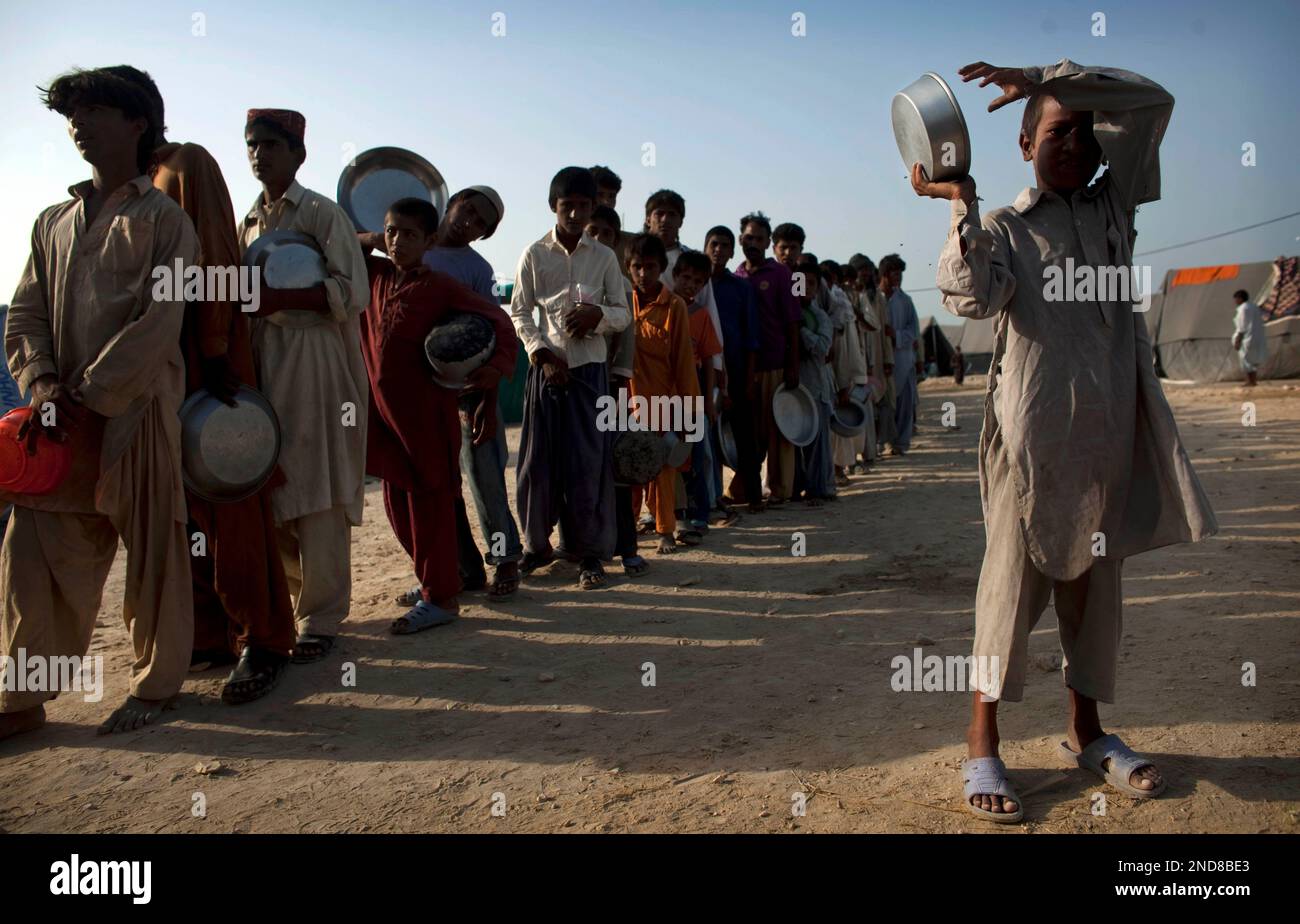 Pakistani men line up as they are given a fresh meal at a camp for ...