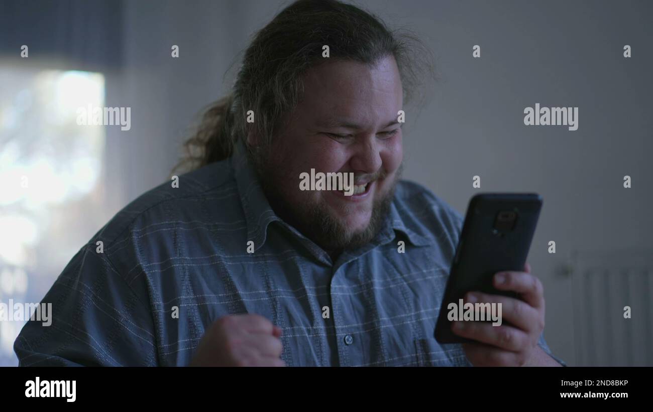 One excited fat man celebrates success in front of computer. close up ...