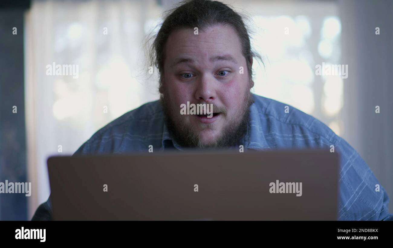 One excited fat man celebrates success in front of computer. close up ...