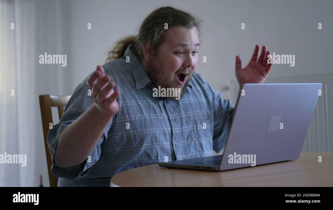 One excited chubby guy celebrating success in front of laptop computer ...