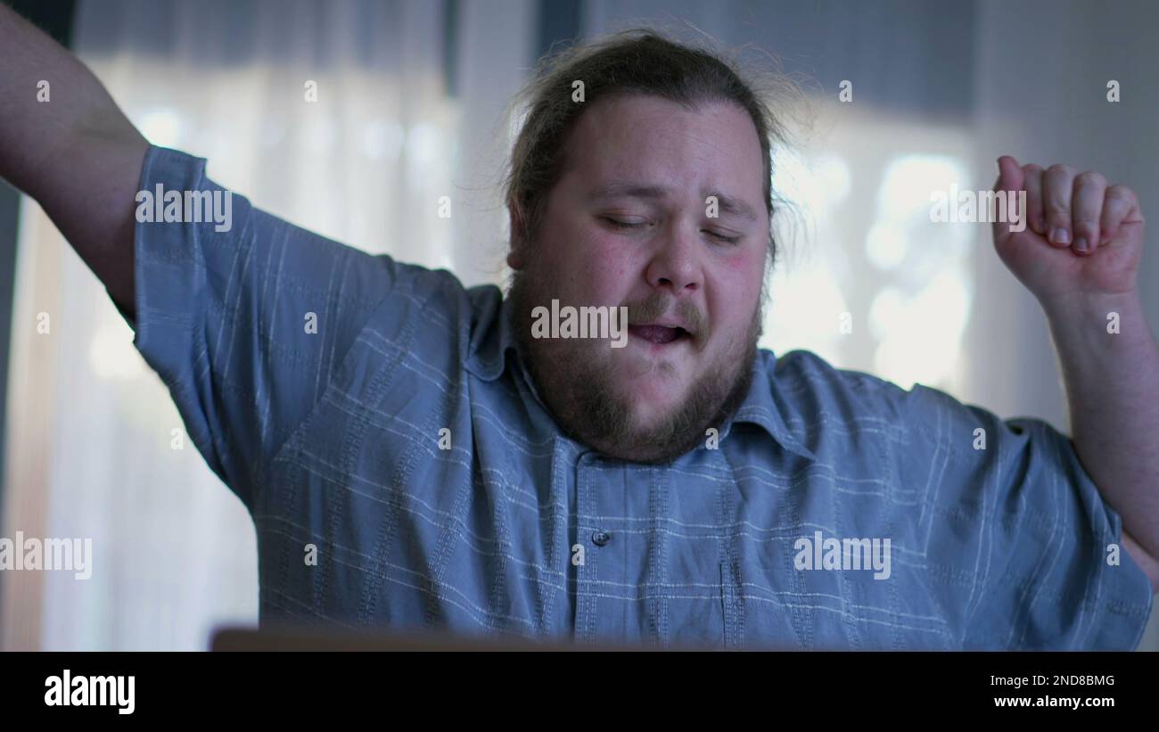 One excited fat man celebrates success in front of computer. close up ...