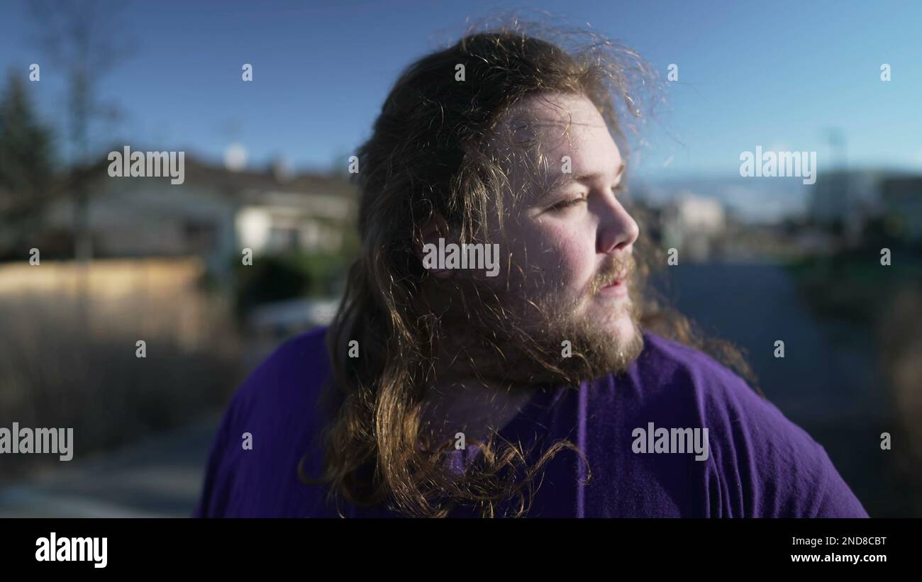 One funny overweight young man shaking head with long hair. Happy free ...