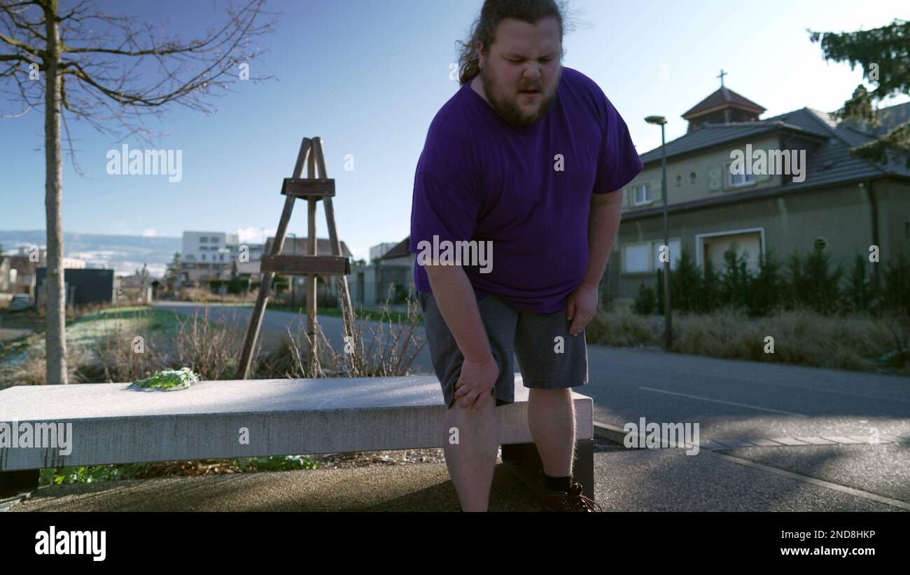 Person suffering knee pain. One overweight young man suffering form ...