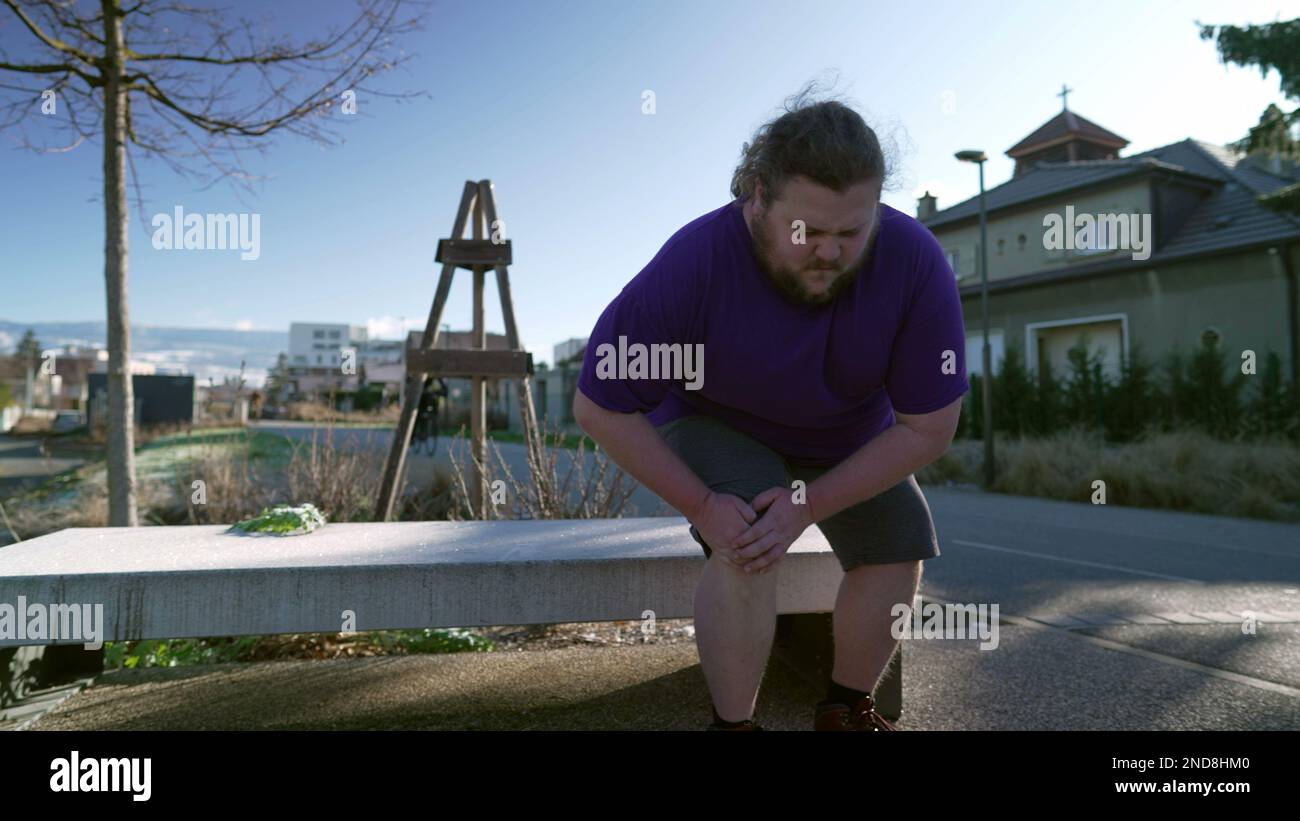 Person suffering knee pain. One overweight young man suffering form ...