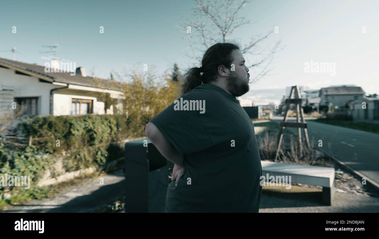 Dramatic moment of person suffering from back pain. An overweight man ...