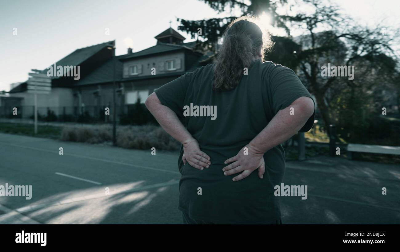 Dramatic moment of person suffering from back pain. An overweight man ...