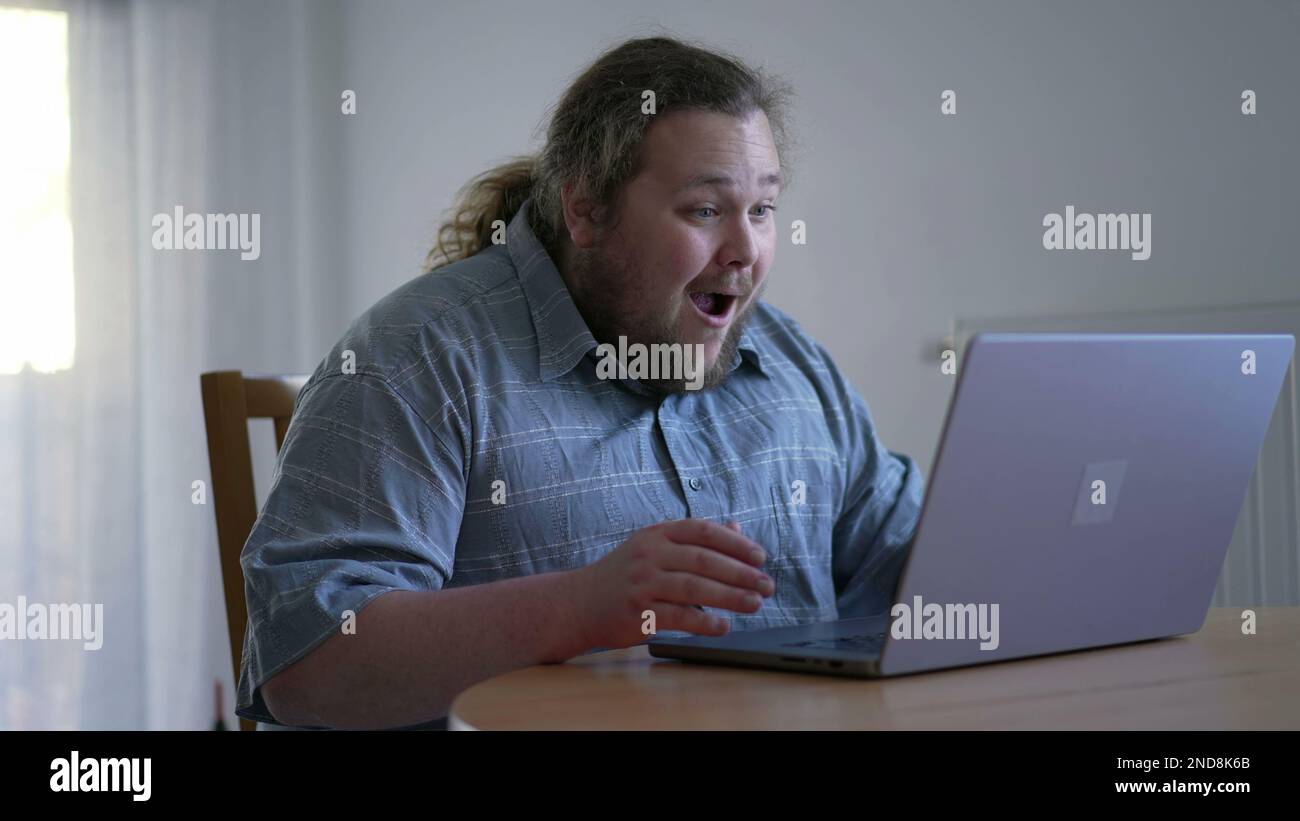 One excited chubby guy celebrating success in front of laptop computer ...