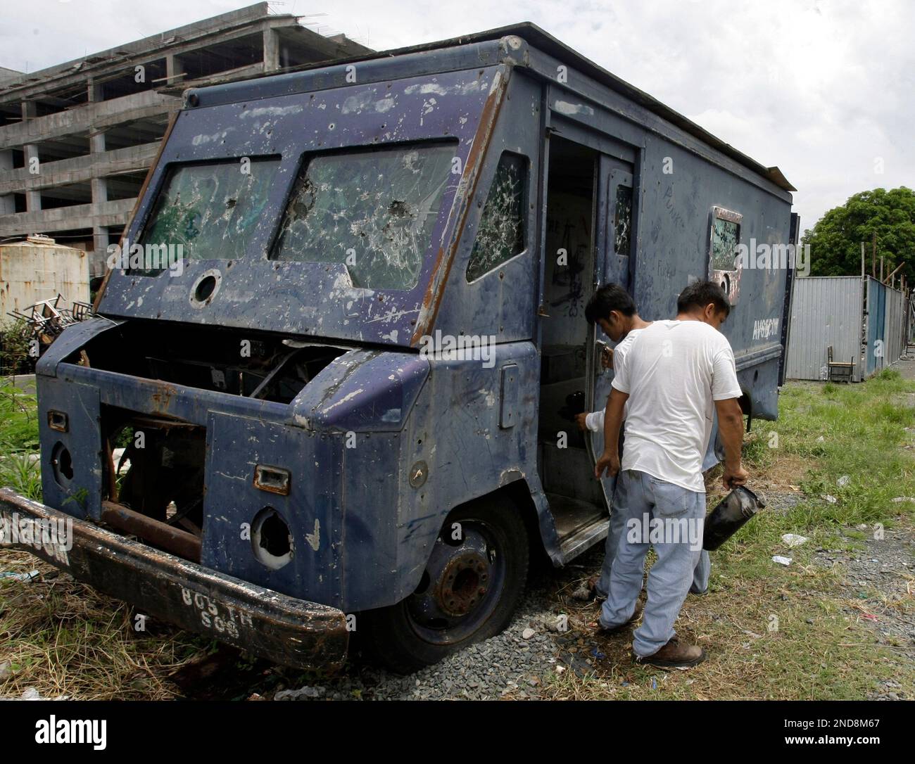 Two workers take out their equipments from an abandoned military van ...