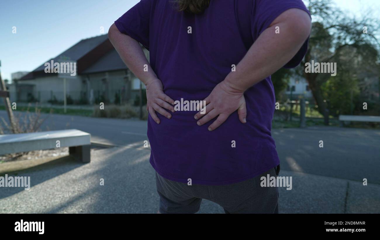 One overweight man suffering from back pain outside. A fat guy having ...