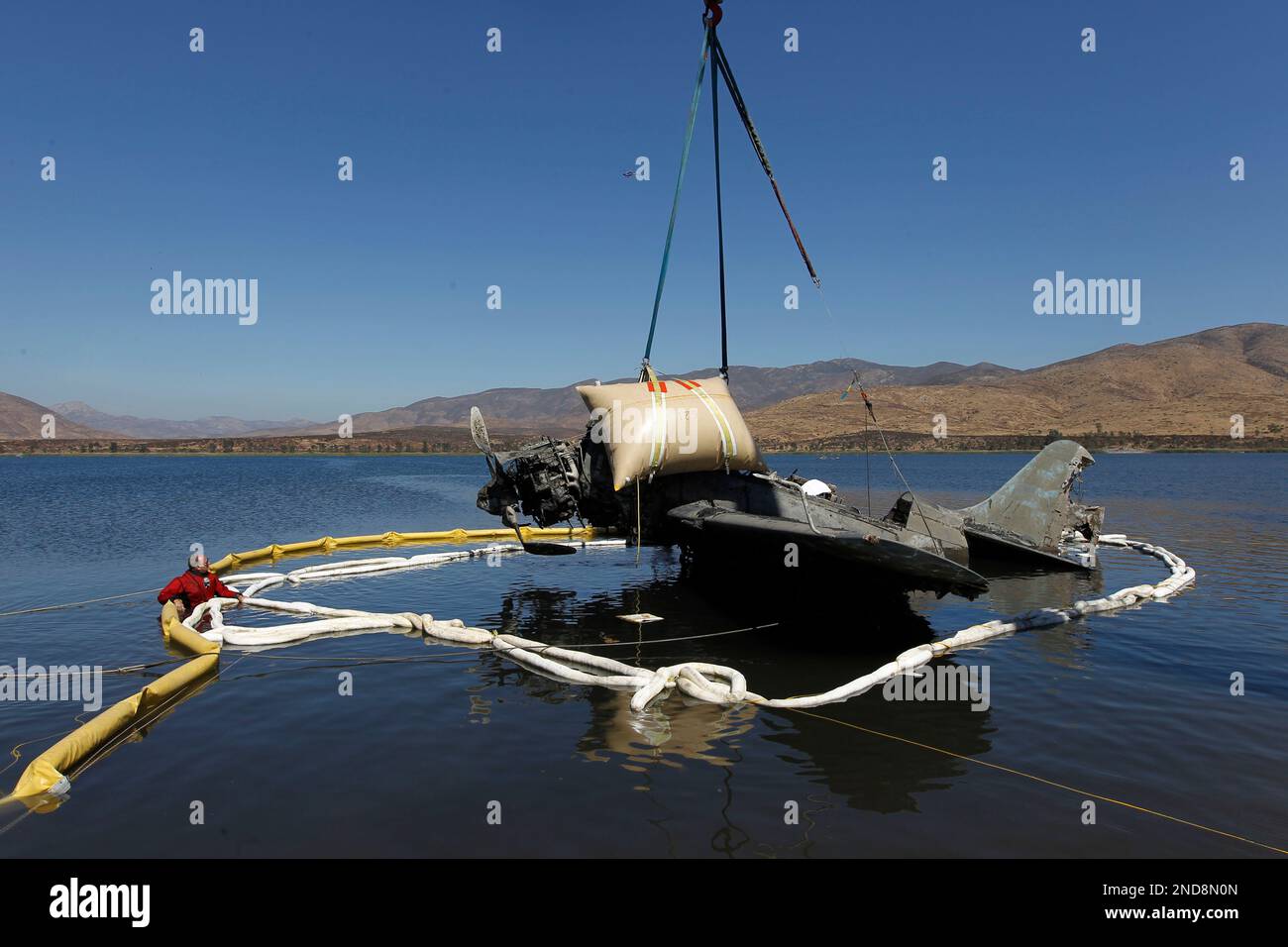 A salvage diver works to remove a SB2C Helldiver after it was recovered ...