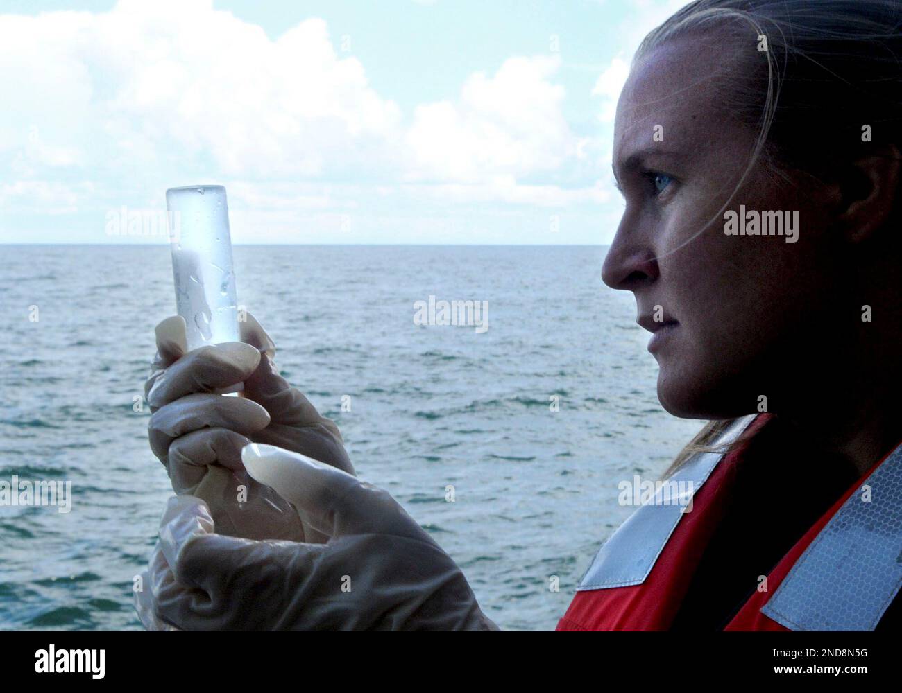 Hydrographer Rachel Medley observes a sample from a water column ...