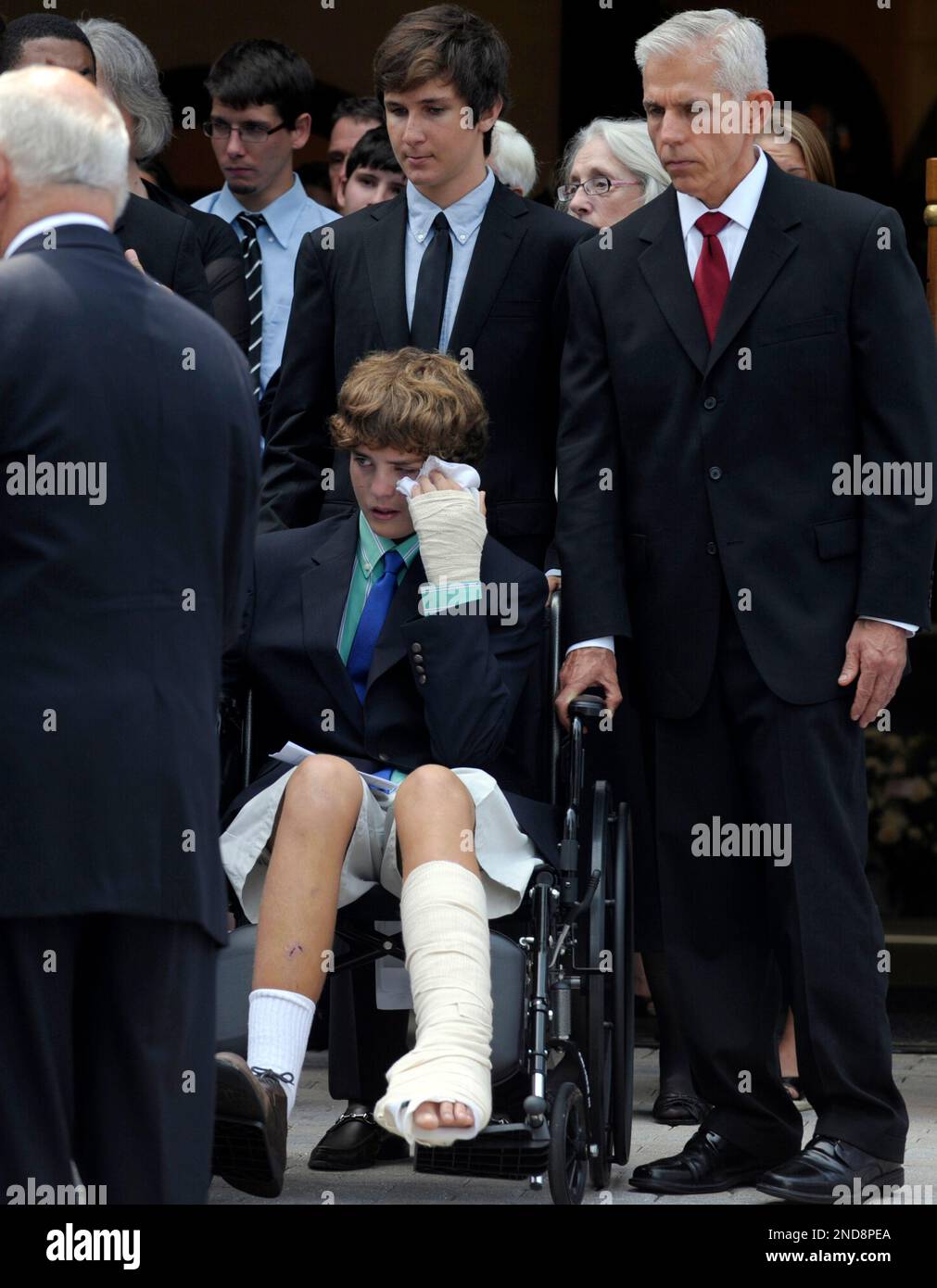 William "Willy" Phillips Jr., is pushed in a wheelchair by his friend ...