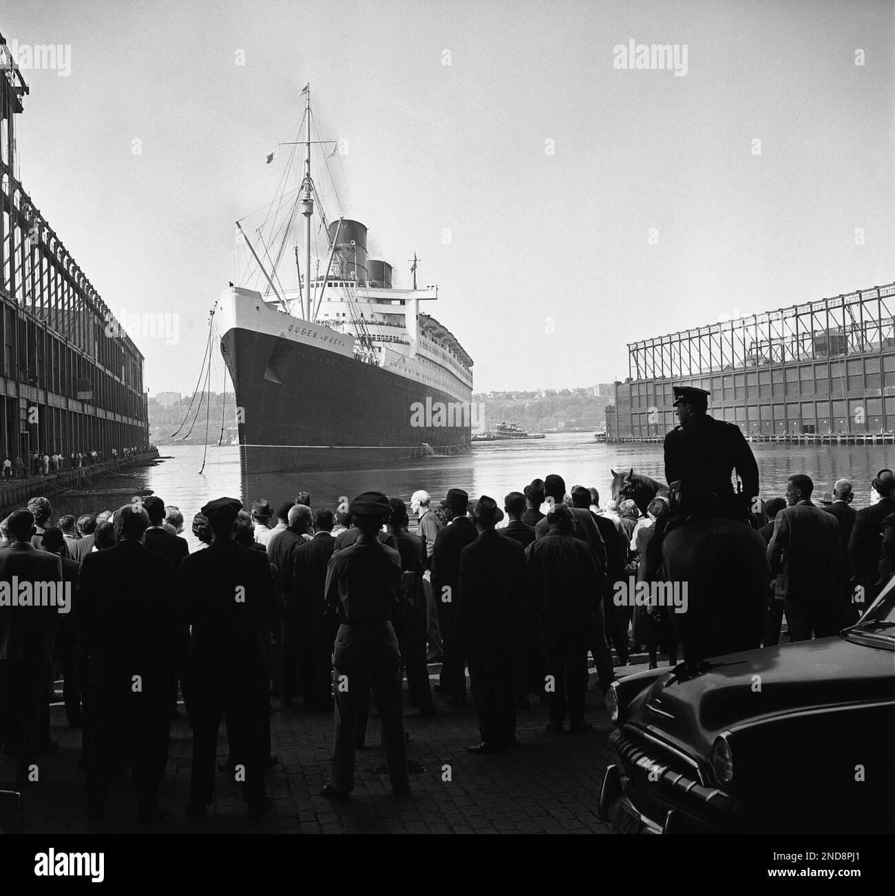 Crowd at Pier 90, Hudson River, watches the liner Queen Mary edge ...