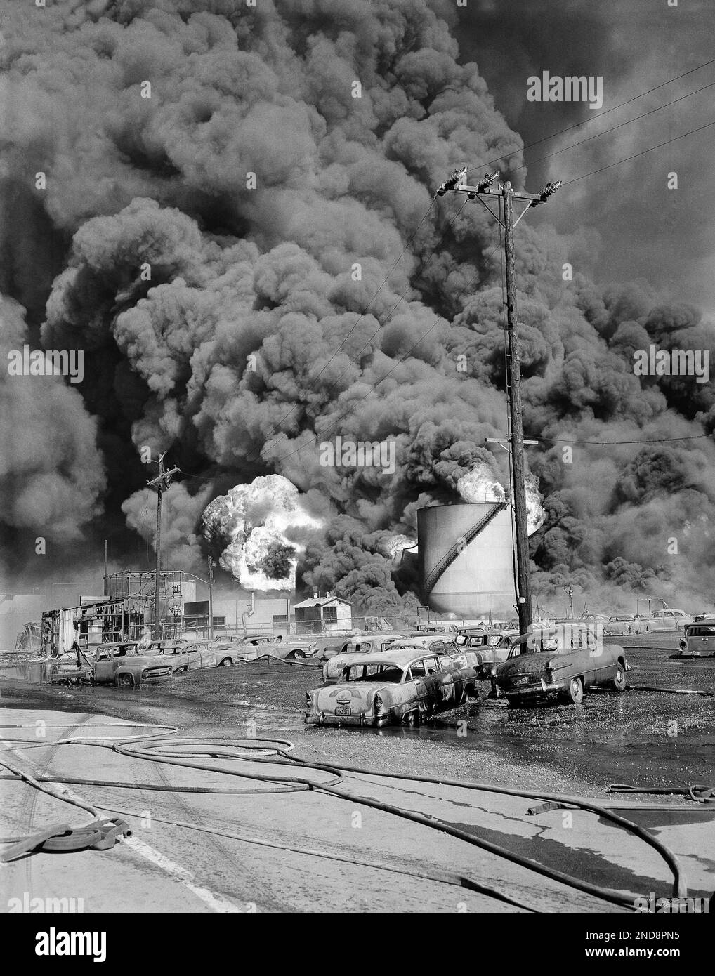 Flame bursts from several of more than a dozen huge oil tanks which ...