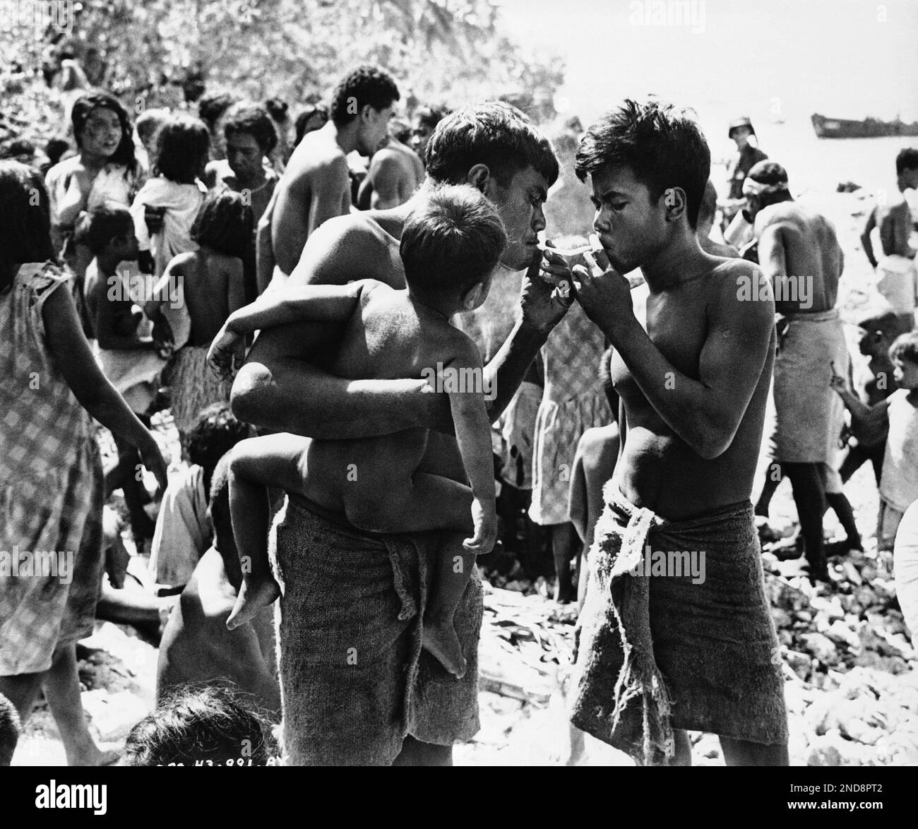 Two natives of the Gilbert Island Light American cigarettes on Red ...