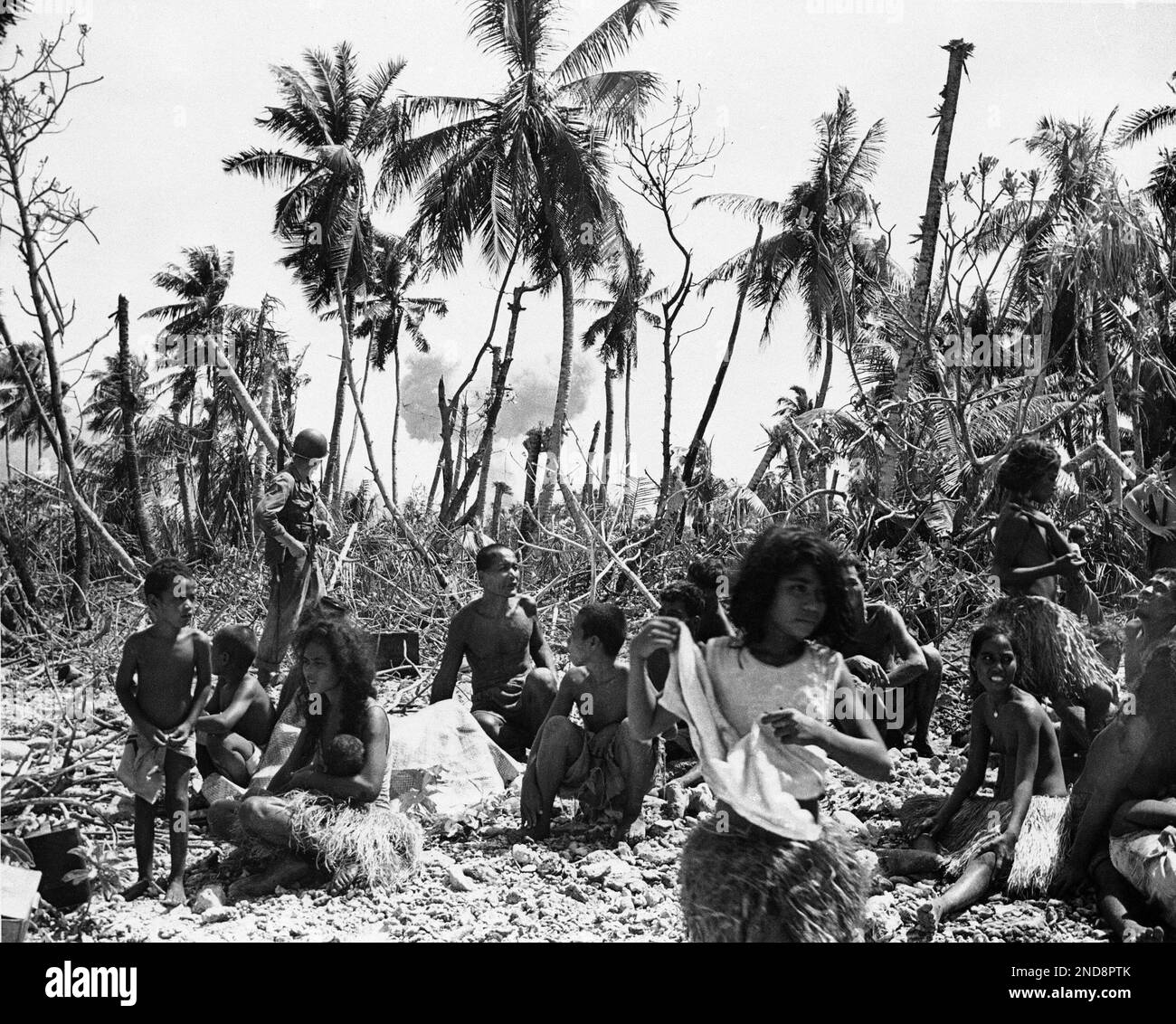 These Gilbertese natives huddle on Red Beach, Butaritari Island, Makin ...